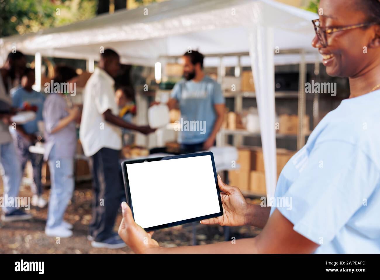 Image shows friendly african american lady carrying tablet with ...