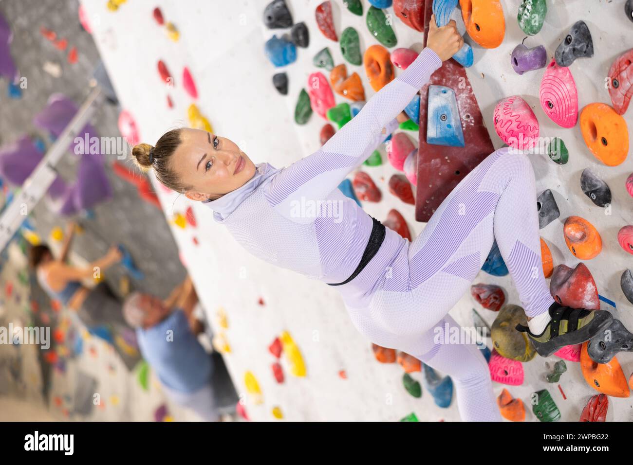 Adult woman practicing rock climbing on climbing wall Stock Photo - Alamy