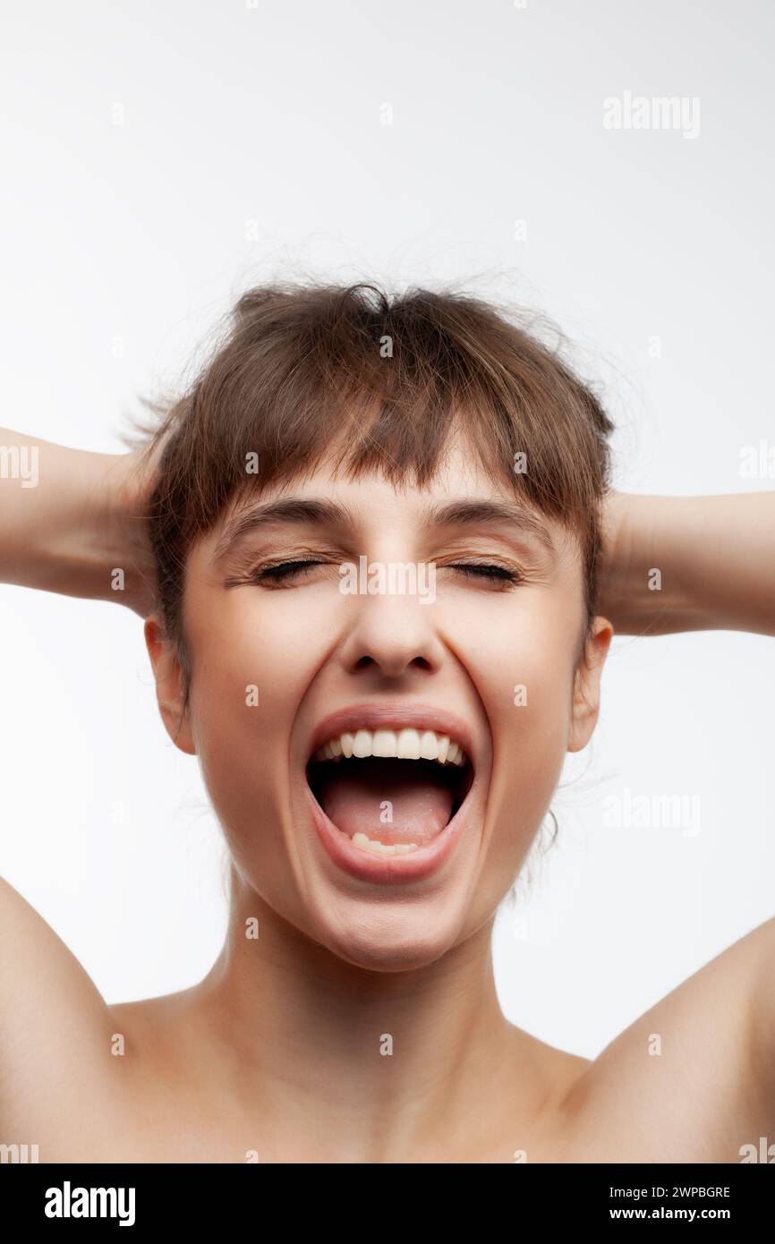 studio portrait of a screaming beautiful brunette girl with short hair ...
