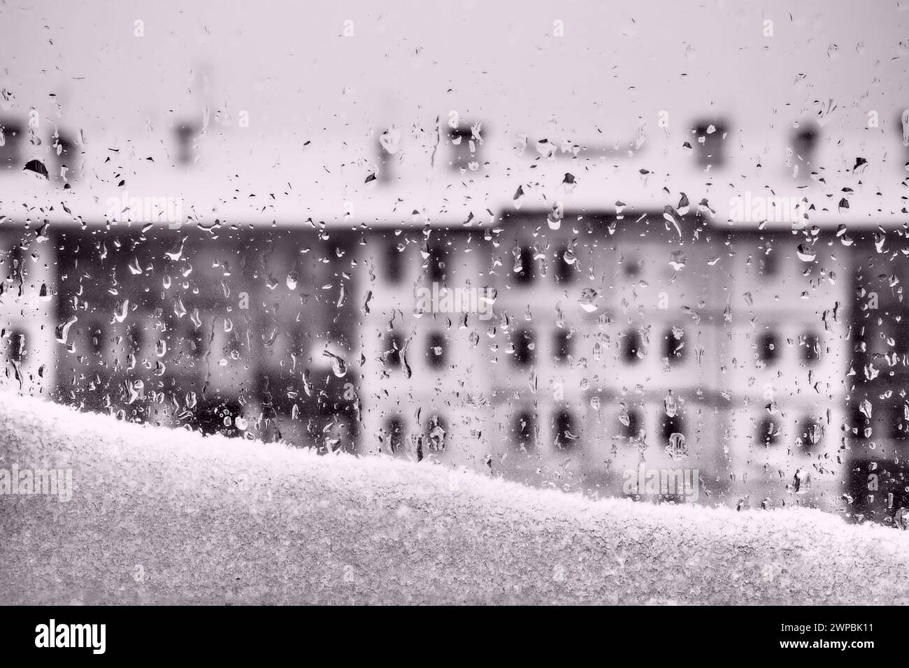 View from the window to the winter thaw. Melting snowdrift and drops on ...