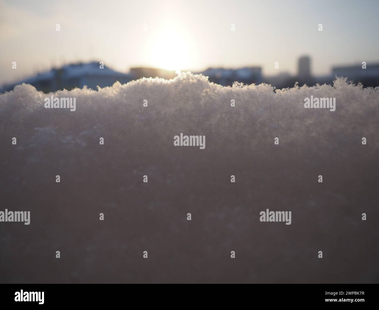 Sunset in the winter. Snow and snowflakes. City skyline. Houses and ...