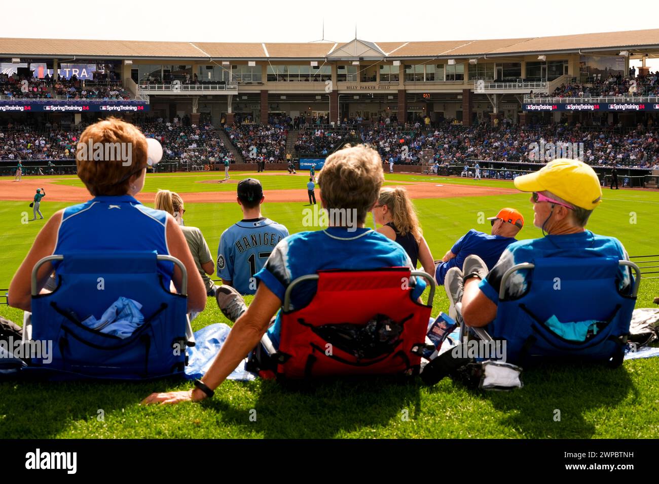 Fans sit in camping chairs on the outfield lawn during a spring ...