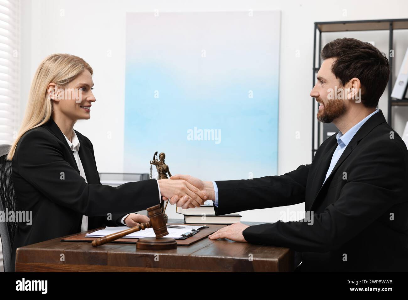 Lawyer shaking hands with client in office Stock Photo - Alamy