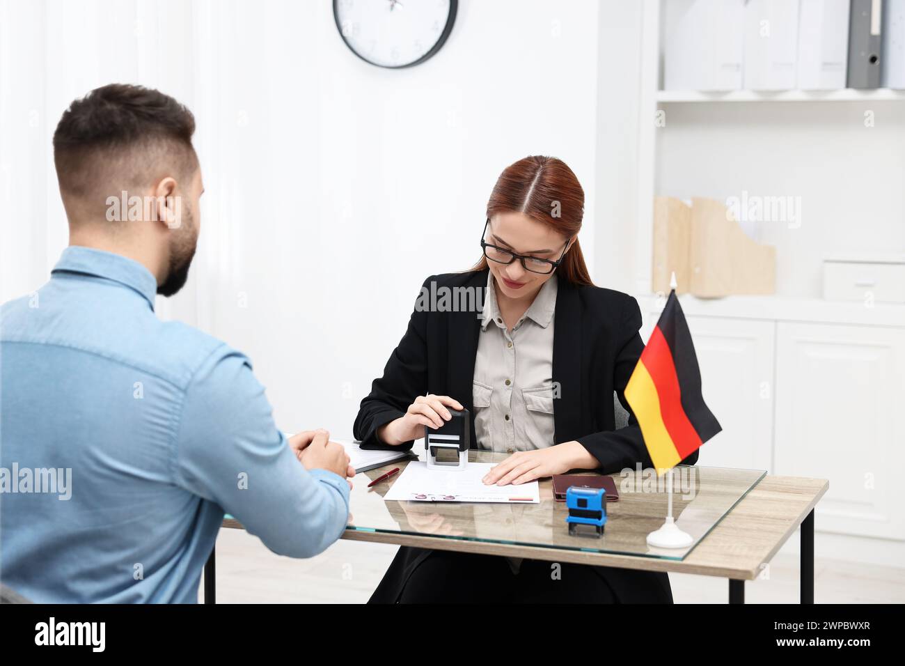Immigration to Germany. Embassy worker approving visa application form ...
