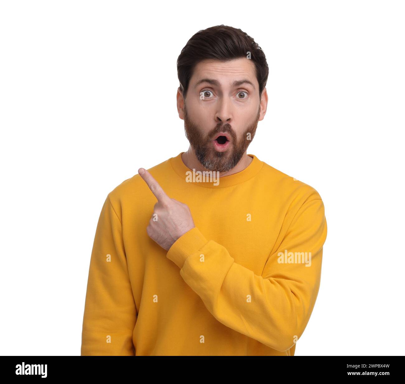 Surprised man pointing at something on white background Stock Photo - Alamy