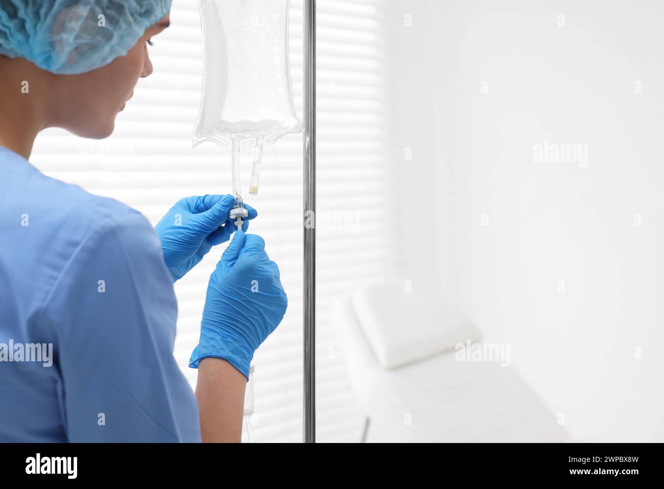 Nurse setting up IV drip in hospital, closeup. Space for text Stock Photo - Alamy