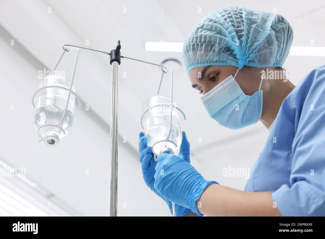 Nurse setting up IV drip in hospital, low angle view Stock Photo - Alamy