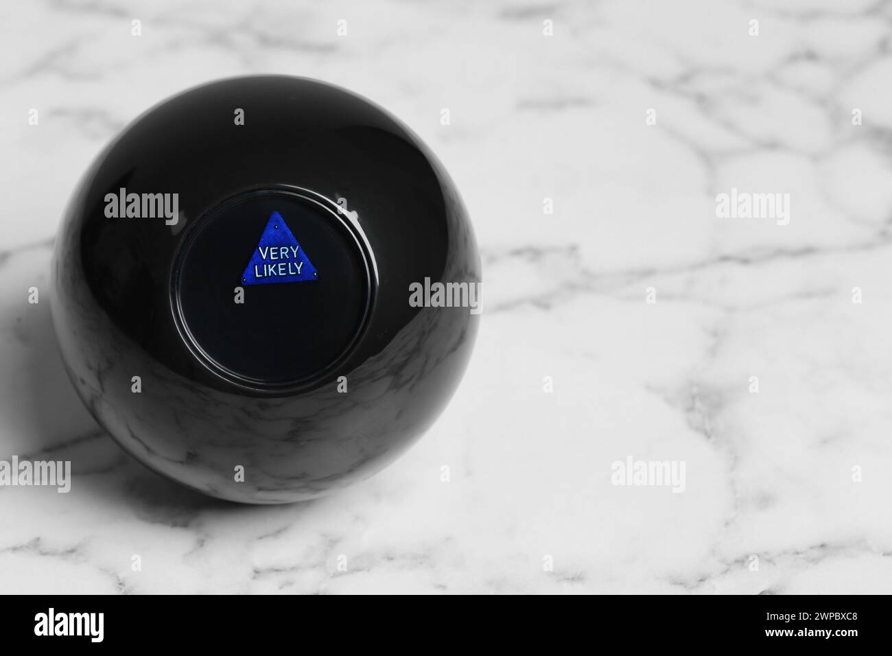 Magic eight ball with prediction Very Likely on white marble table ...