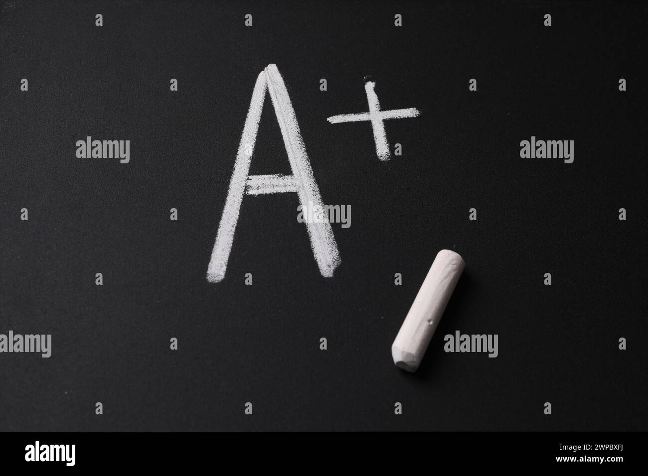 School grade. Letter A with plus symbol and chalk on blackboard, top ...