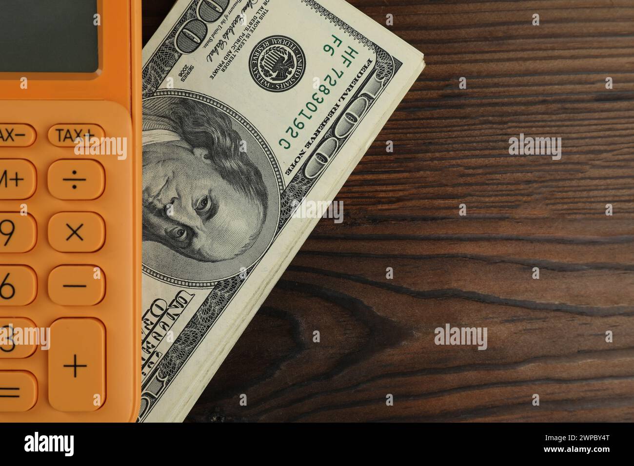 Money exchange. Dollar banknotes and calculator on wooden background ...