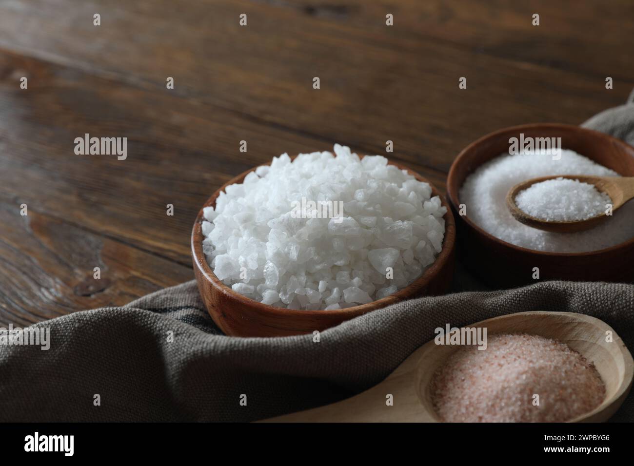 Different types of organic salt on wooden table, closeup Stock Photo ...