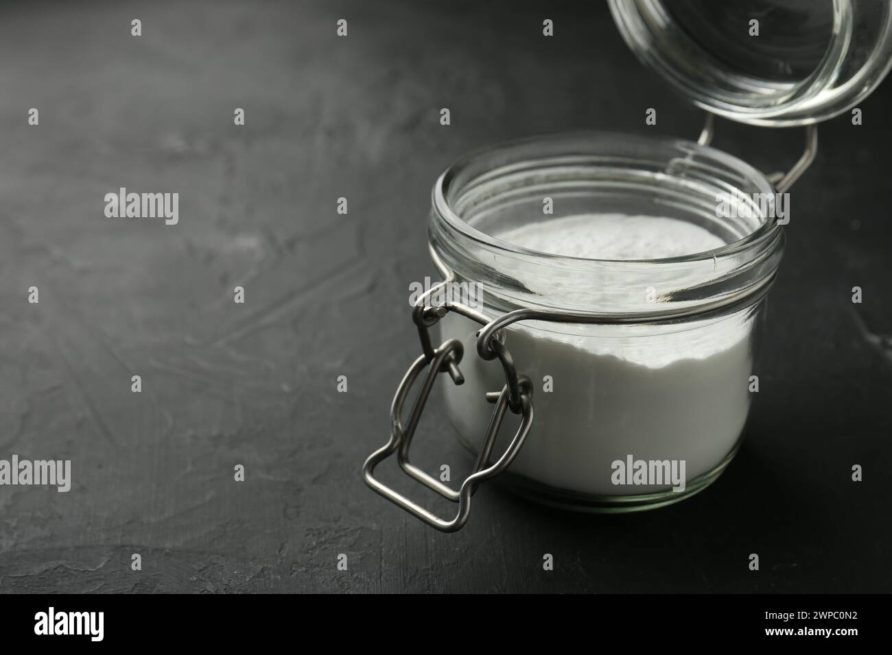 Baking powder in jar on black textured table, space for text Stock ...