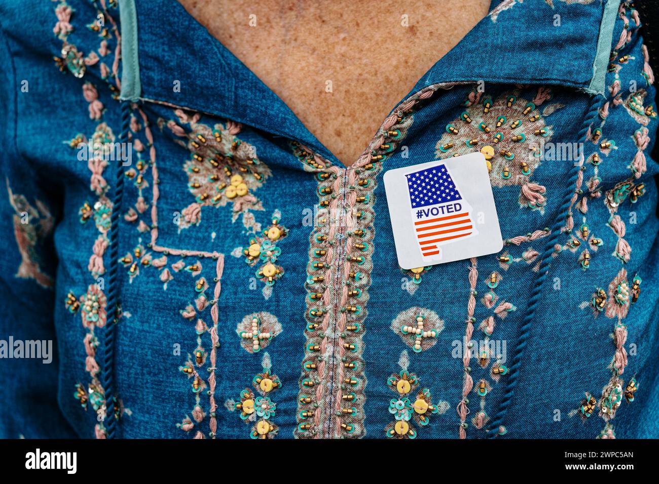 Woman with an I voted sticker on her shirt or blouse after voting in an ...
