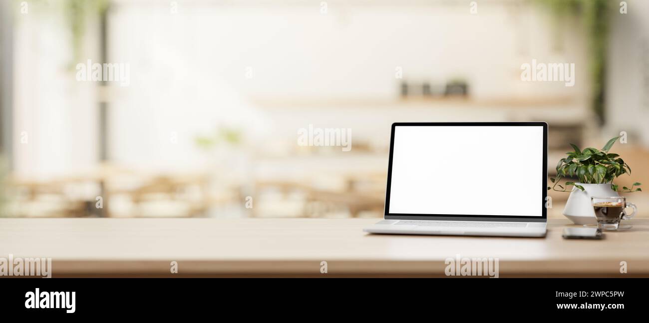 A white-screen laptop computer, a coffee cup, and a presentation space ...