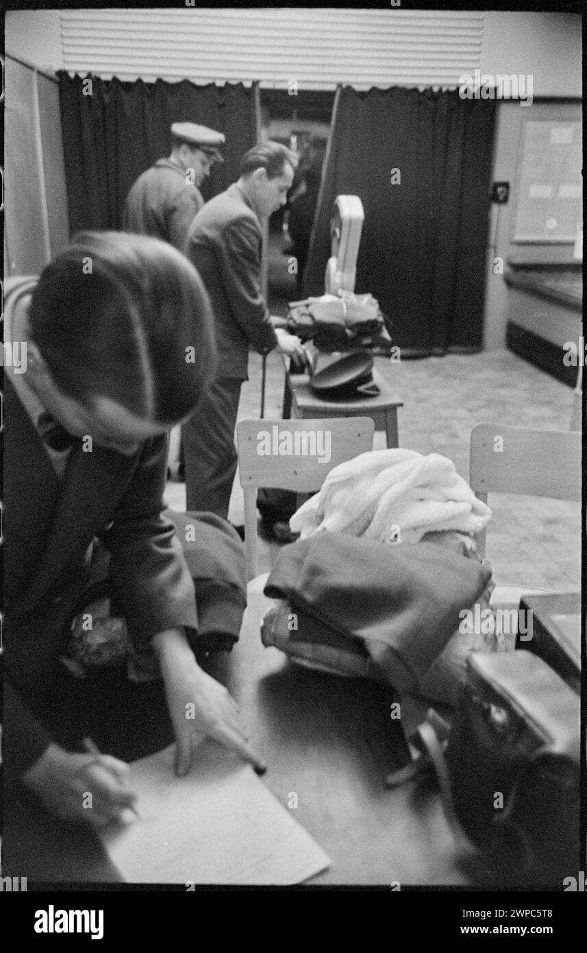 Customs officers performing passport and luggage inspections at Warsaw ...