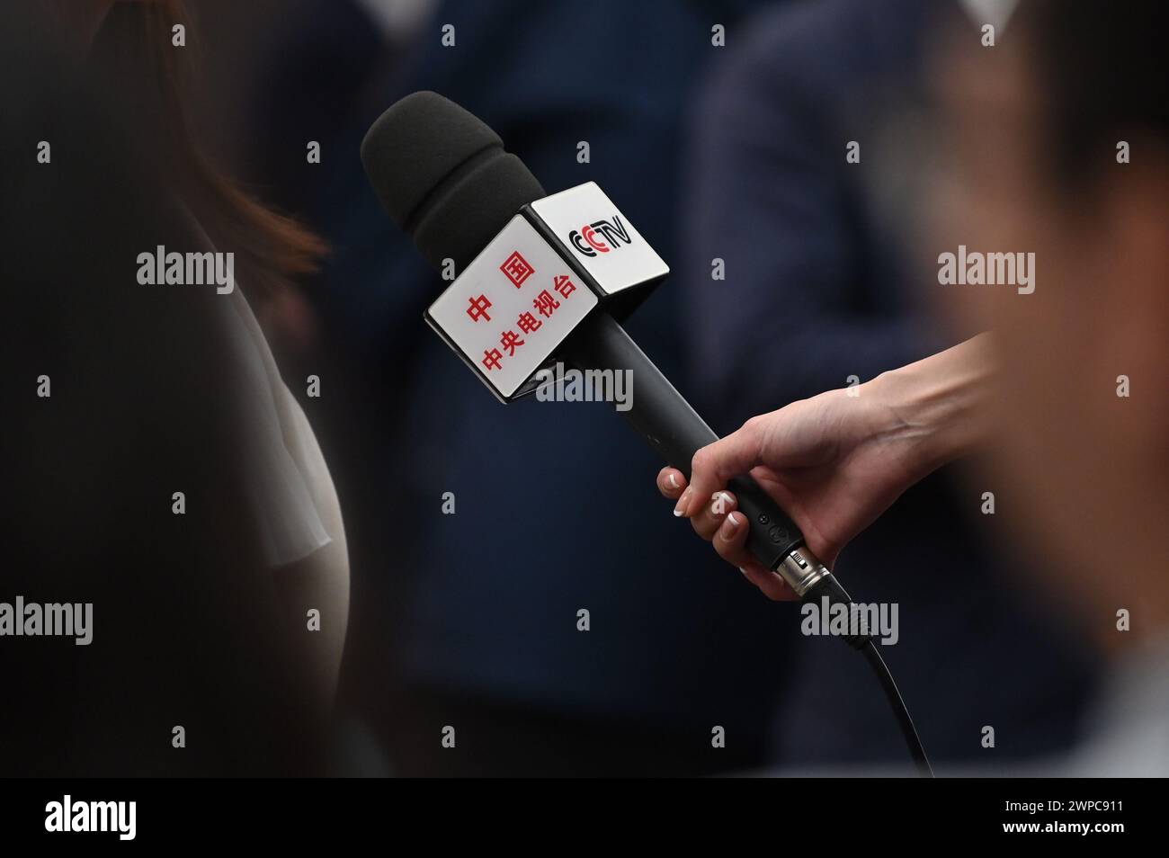 Peking, China. 07th Mar, 2024. A reporter holds the microphone of ...