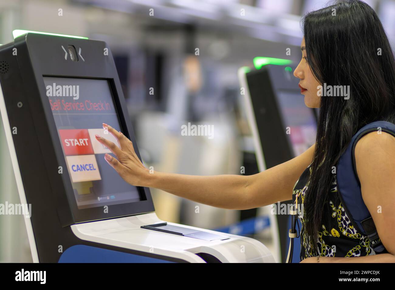 Young Asian woman using self check-in kiosks in airport terminal Stock ...