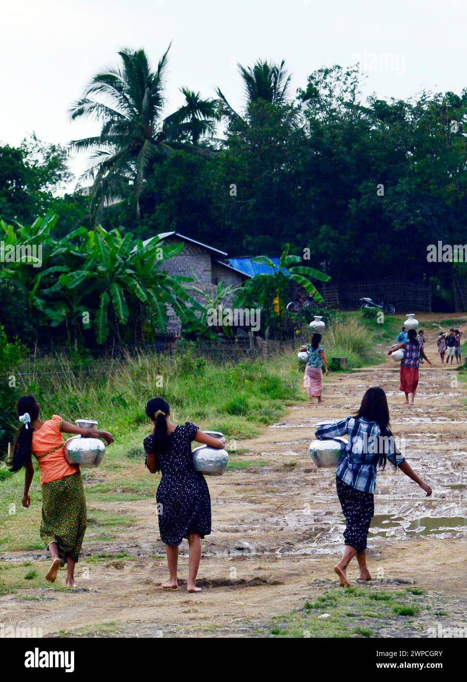 Young Arakanese girls carrying water jugs back to their village in ...