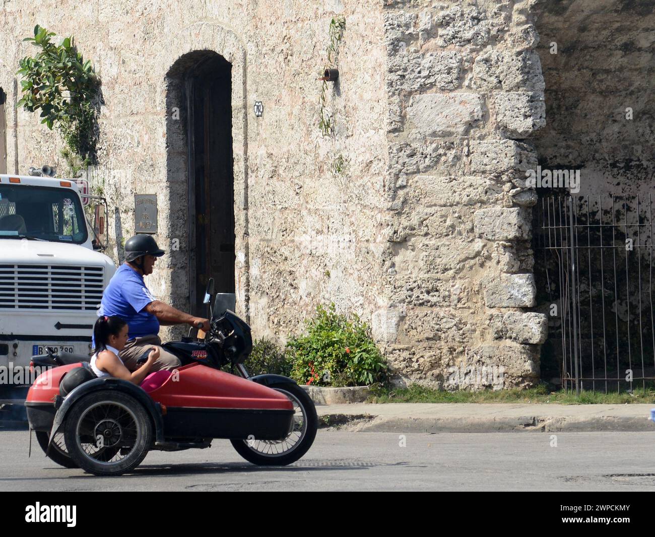 A Cuban man driving his motorcycle with a sidecar in Havana, Cuba Stock ...