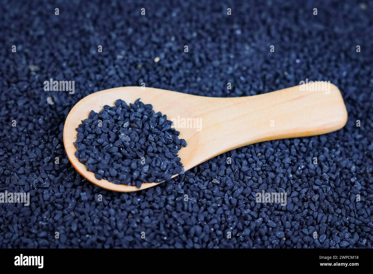 Black Cumin seeds in wooden spoon on Black Cumin background Stock Photo ...