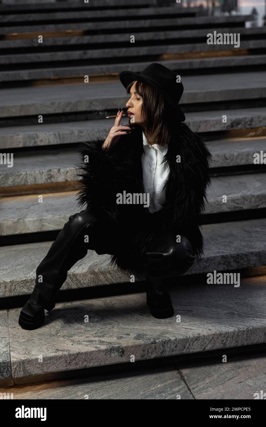 Model smokes.Outdoor fashion portrait of young beautiful girl wearing ...