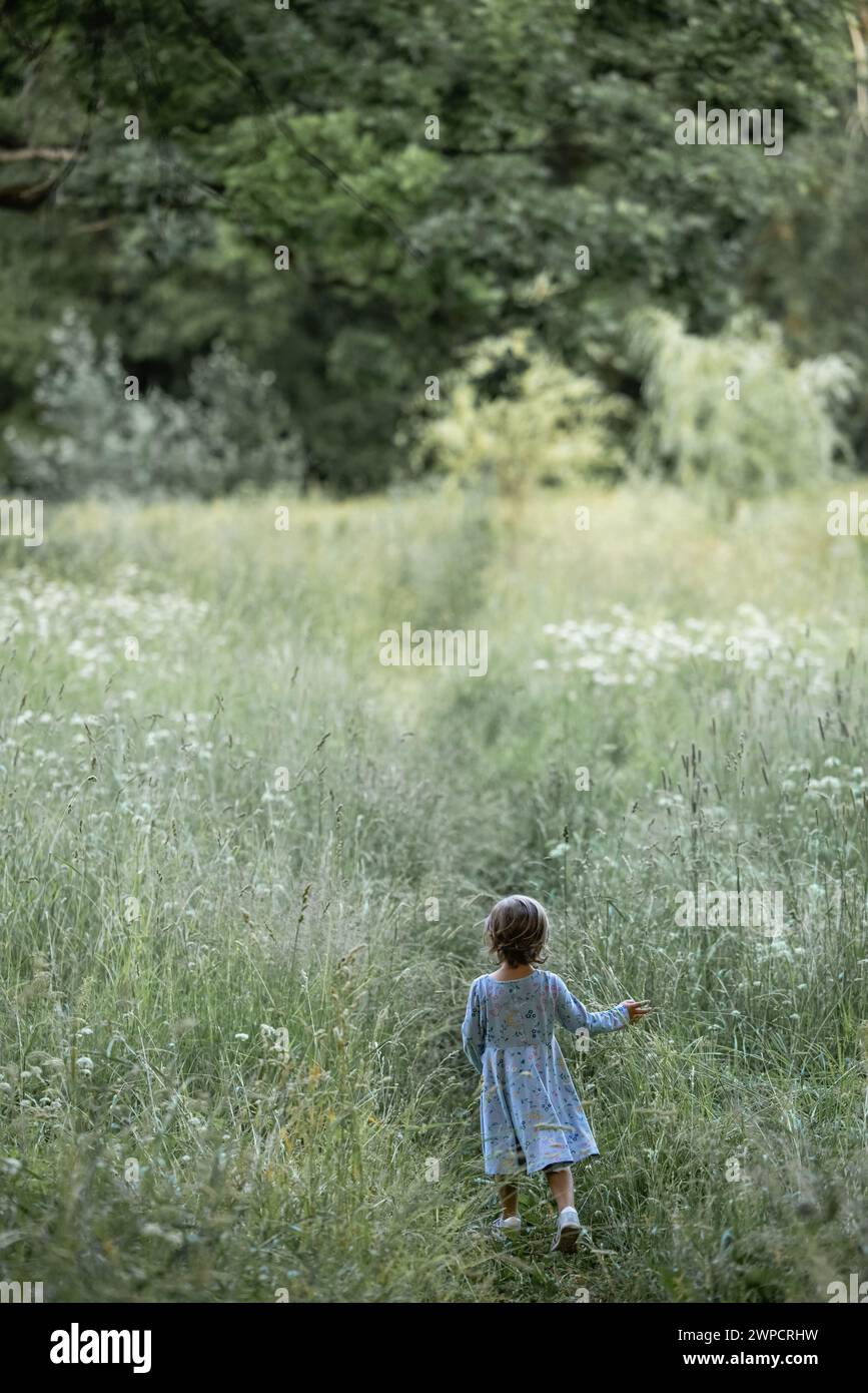 Little girl running on meadow with sunset Stock Photo - Alamy