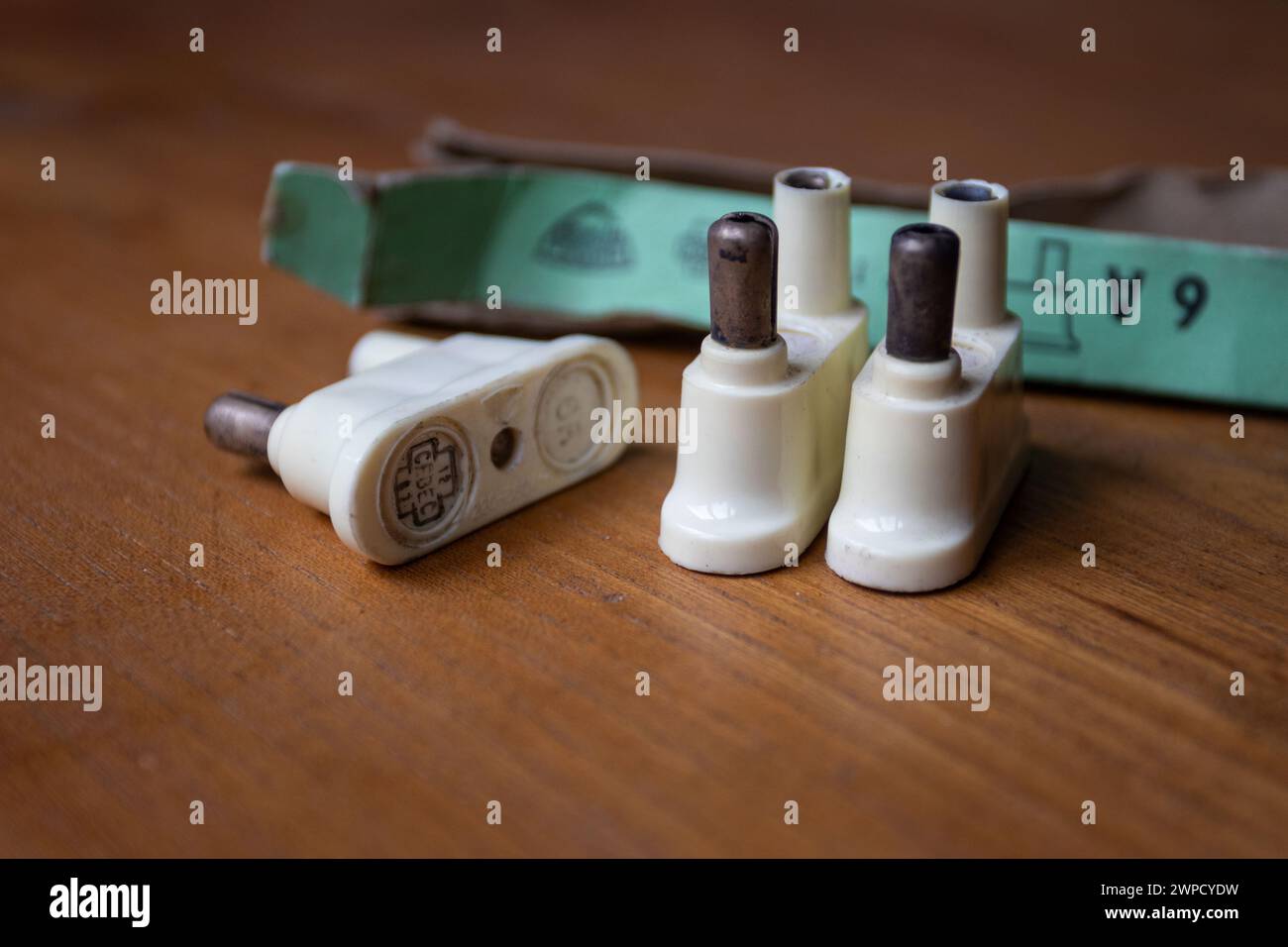 A group of old 6 amp electric fuses, in close up standing on a wooden ...