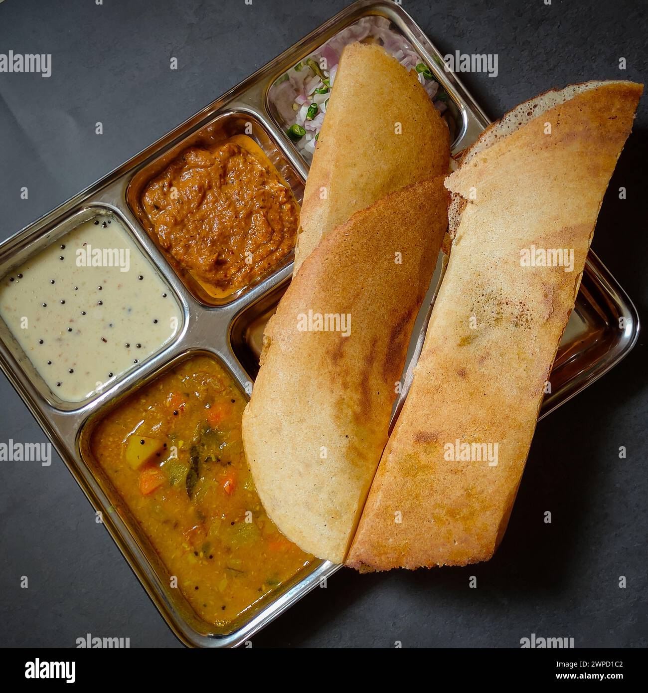 An Indian Style DOSA in a container with compartments for side dishes ...