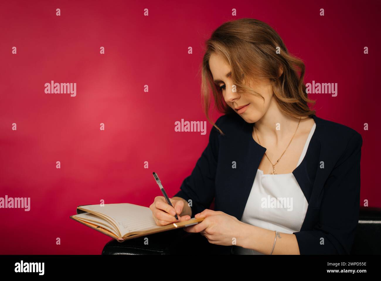 Image of smiling beautiful woman writing down notes while sitting Stock ...