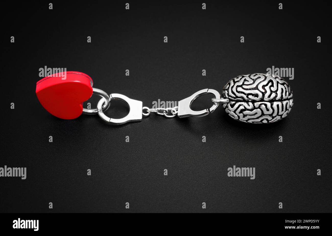 Human brain model is connected to a heart-shaped padlock through small ...