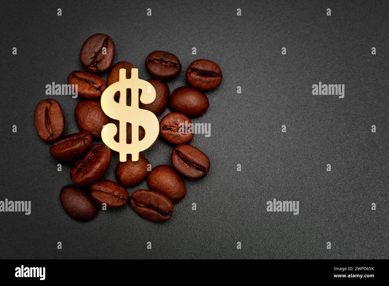 Golden dollar sign placed within a pile of roasted coffee beans against ...