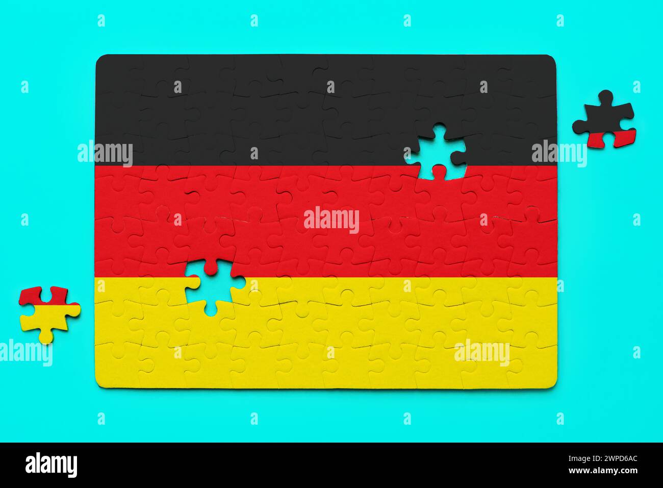 German flag puzzle with only two pieces left to set in place, against a ...