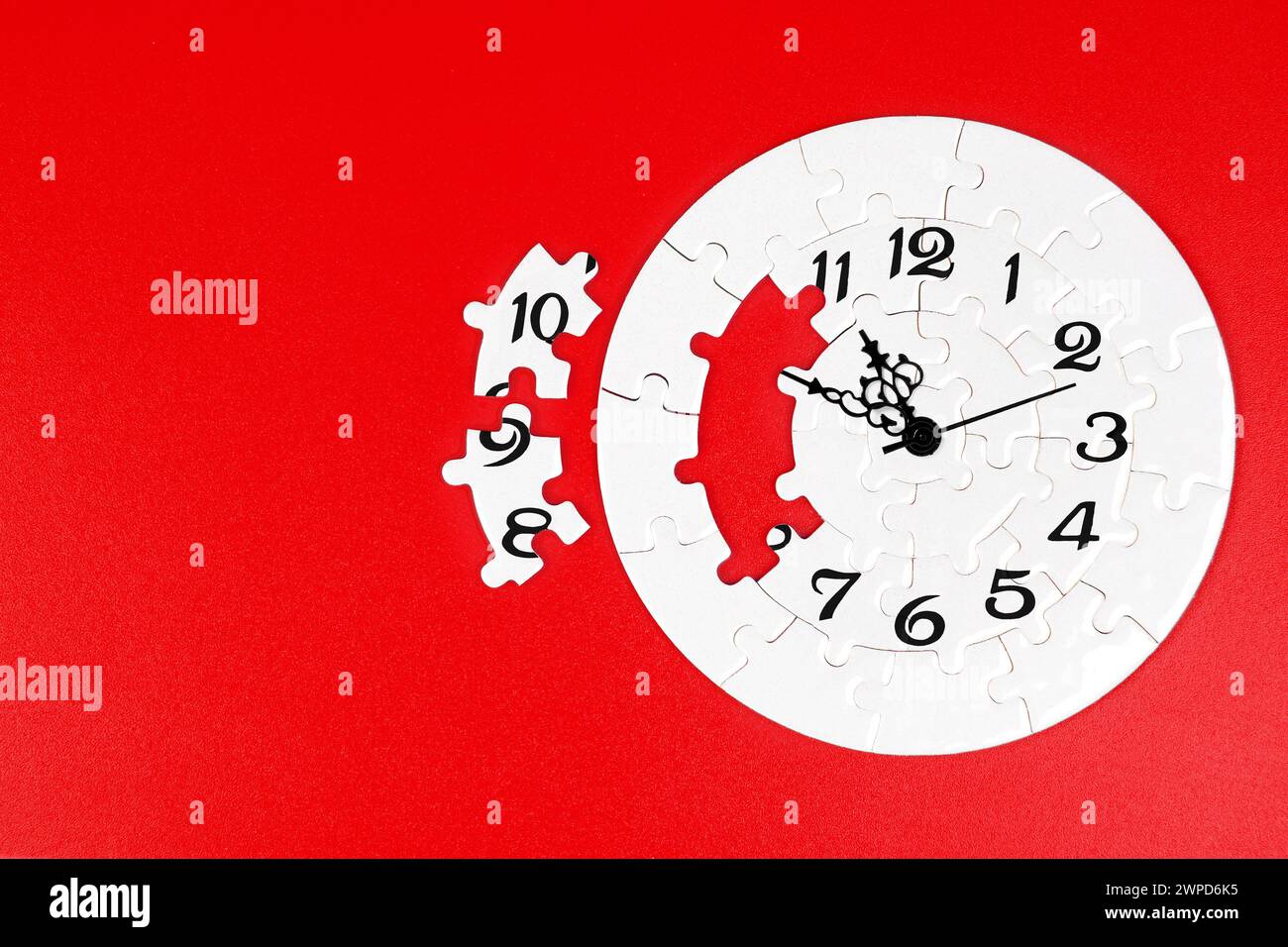 Unfinished clock face jigsaw puzzle with two missing pieces set aside ...