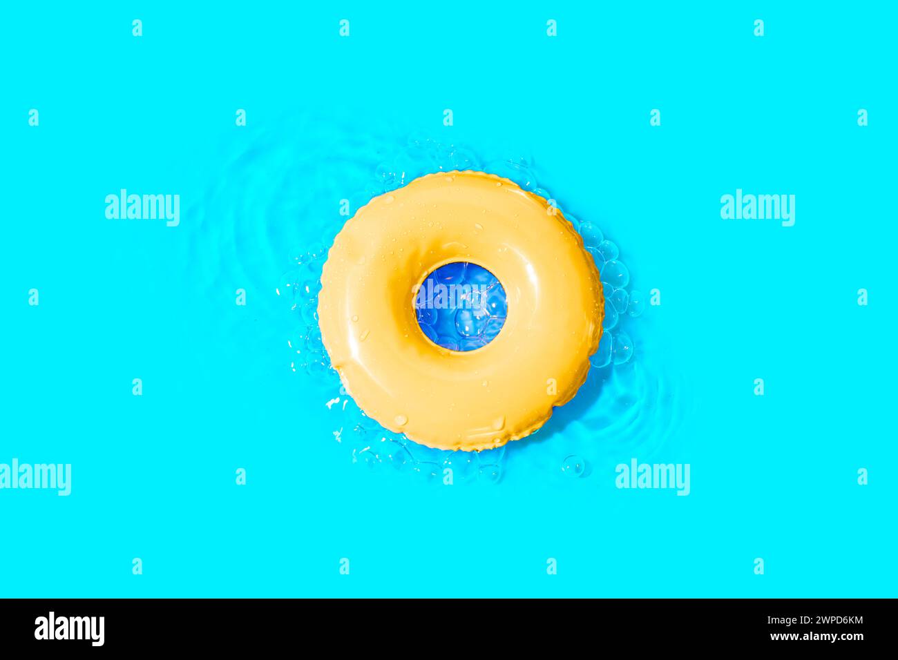 Top-view of a yellow swim ring drifting on the water surface, set ...