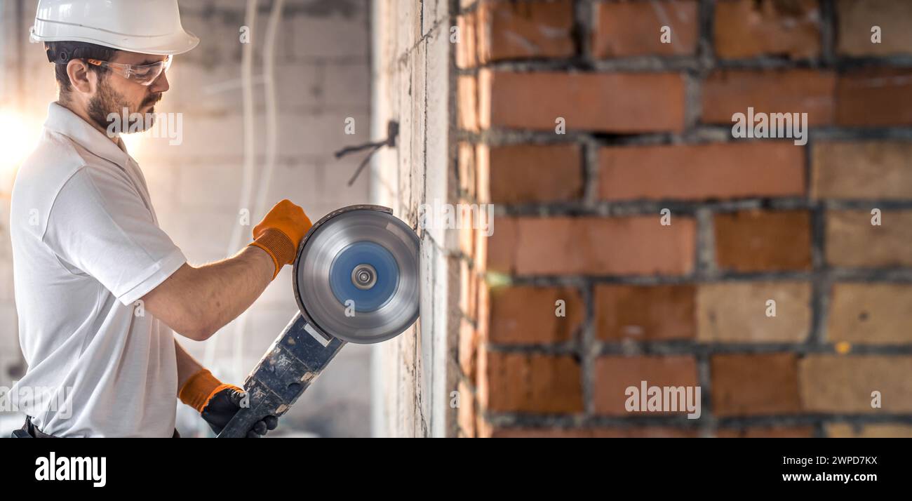 Builder works with a angle grinder to cut bricks and build interior ...