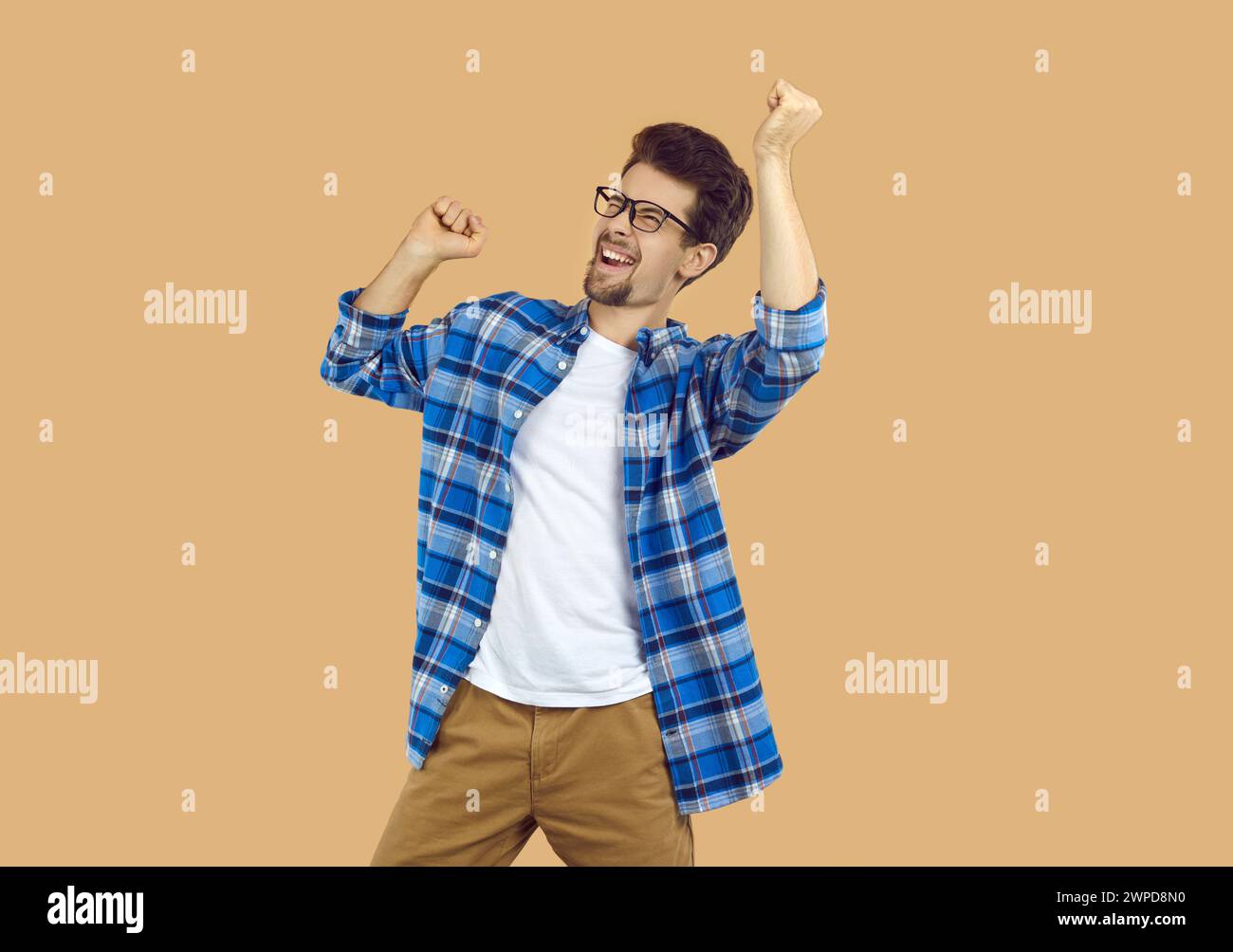 Joyful funny man doing winner dance while celebrating his success or ...