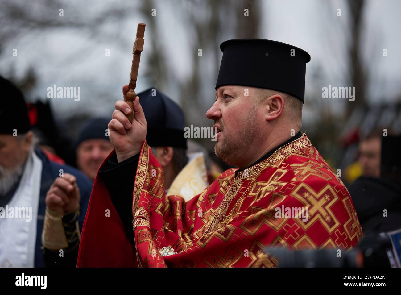 Ukrainian Orthodox Christian priest says a prayer with a cross in hand ...