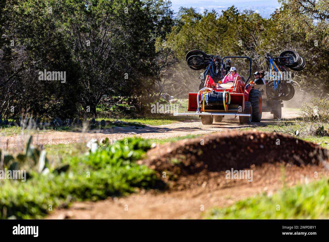 A group of people carrying bicycles on a dusty path in Burnet, United ...