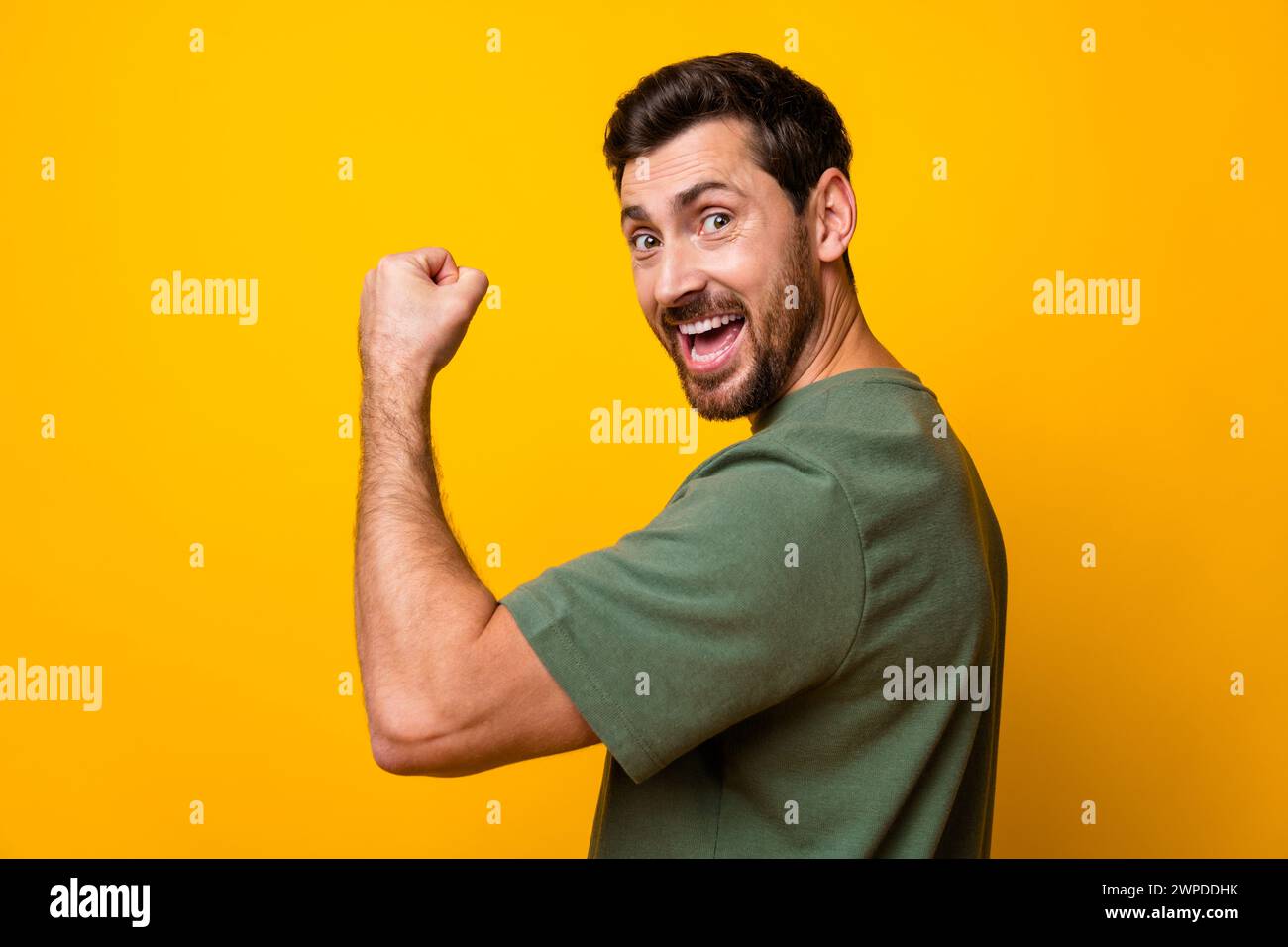 Photo of strong excited man wear khaki t-shirt rising fist showing ...