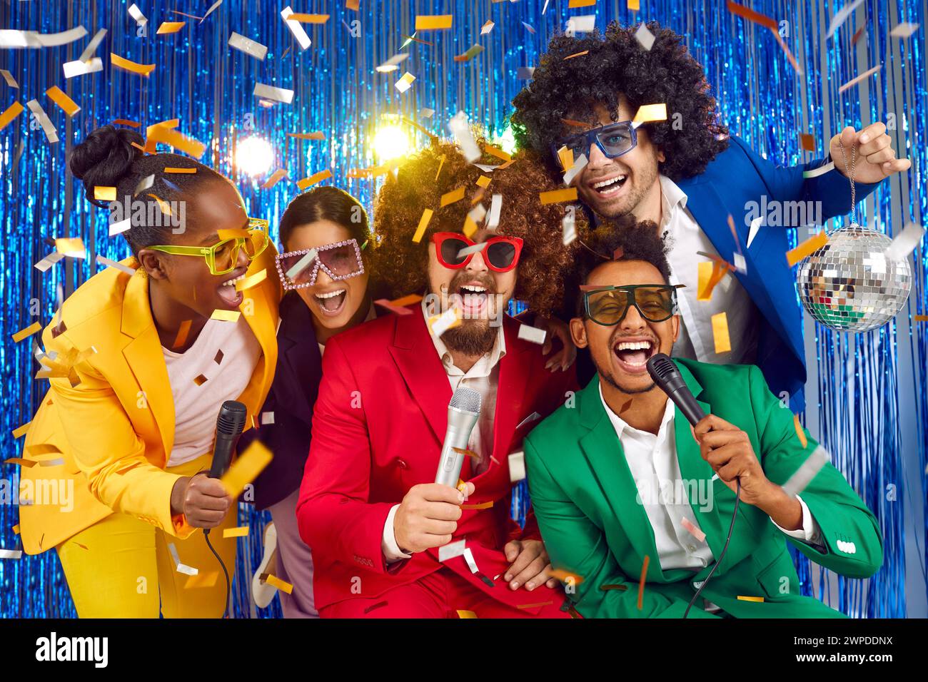 Funny group of young people singing into microphones at party Stock ...