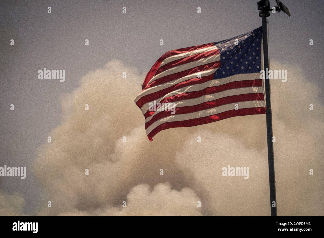 American flag waving in the air with smoke billowing from a house Stock ...
