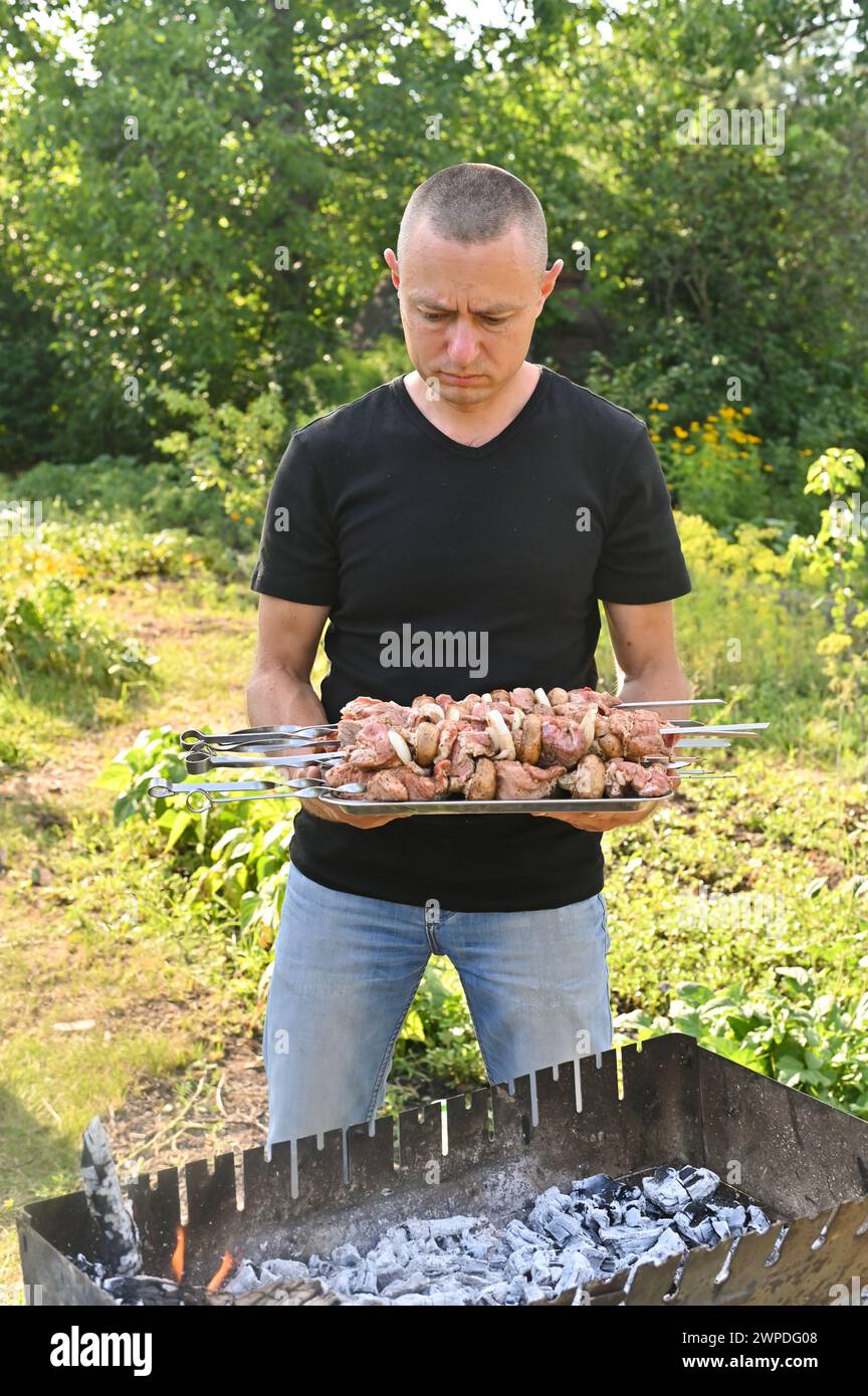 a man lays a barbecue on the grill Stock Photo - Alamy