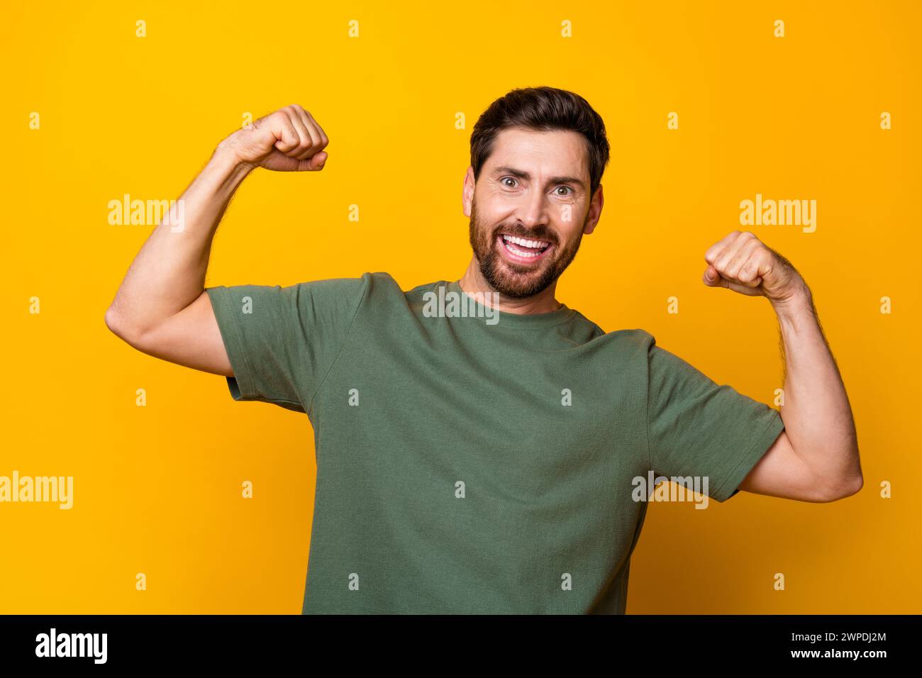 Photo portrait of attractive young man excited hands show muscles ...