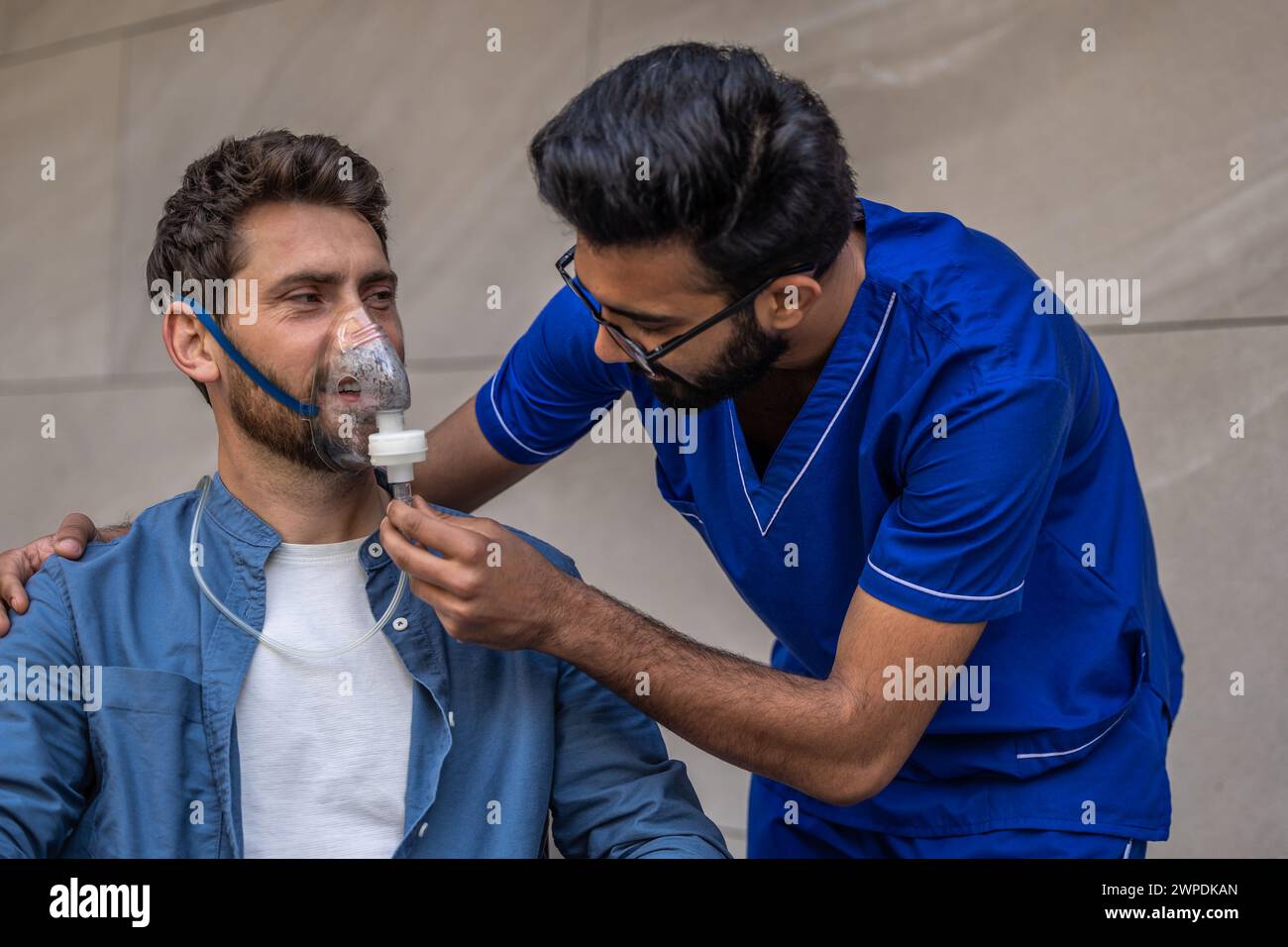 Male nurse putting an oxygen mask on a patient in wheelchair Stock ...