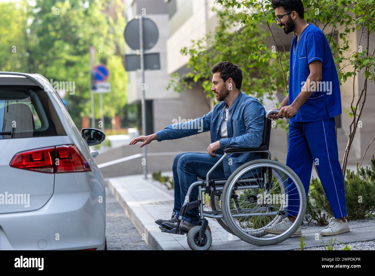 Man on a wheelchair getting into a car Stock Photo - Alamy