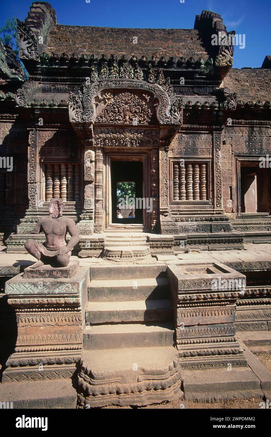 Kneeling statue with stolen head, Banteay Srei temple, Angkor complex ...