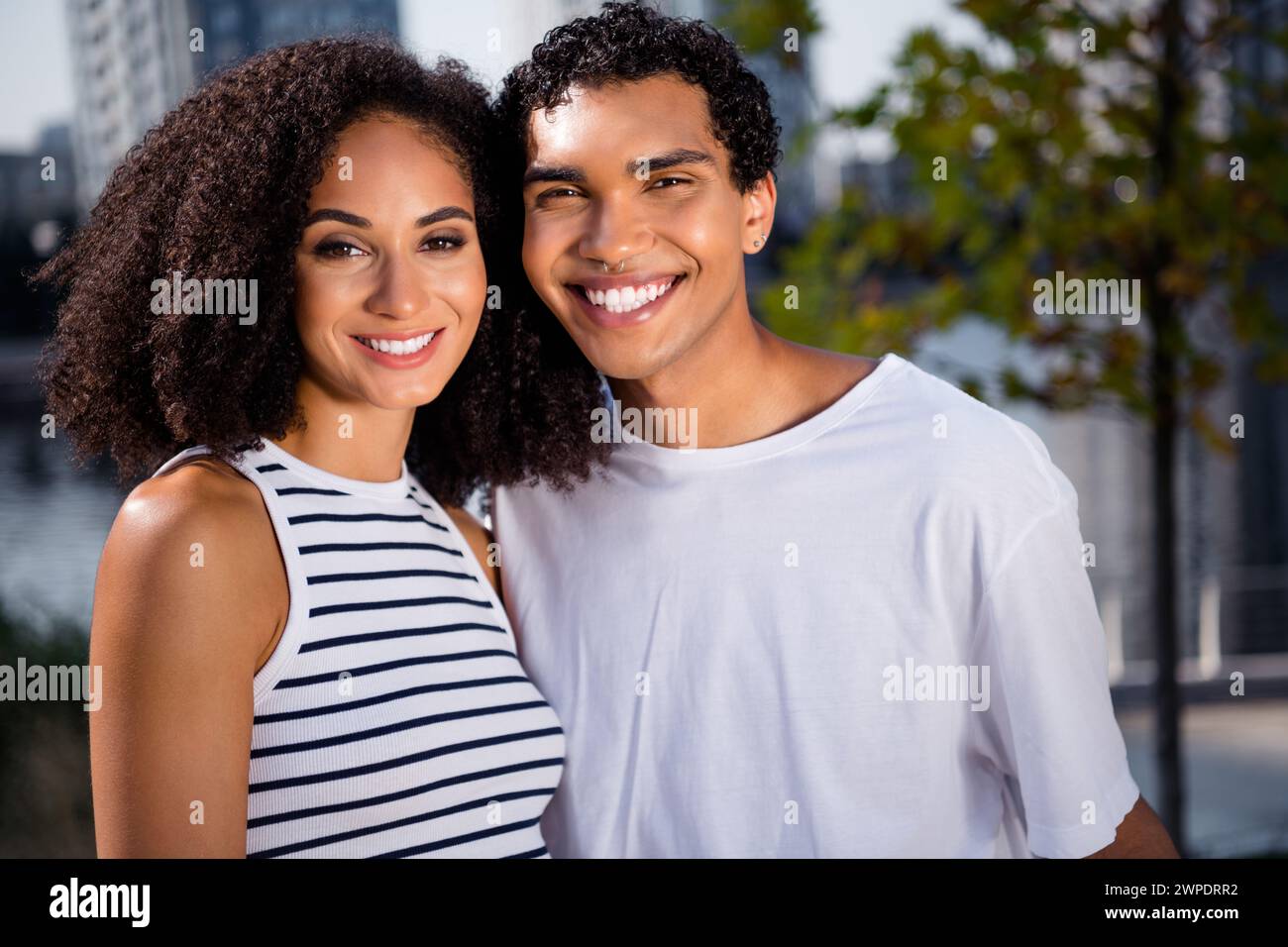 Photo of charming toothy married couple dressed casual outfits cuddling ...