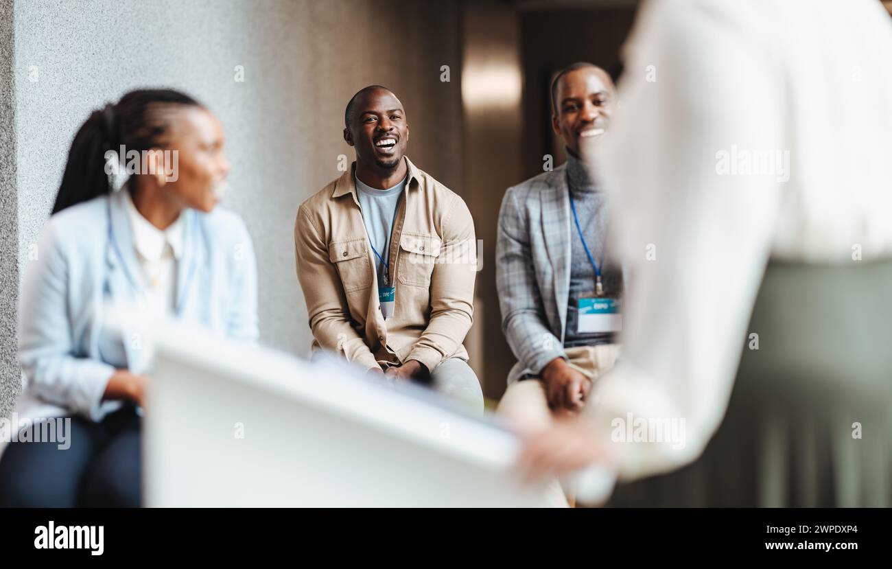 Three professionals smiling and engaging in a casual conversation with ...
