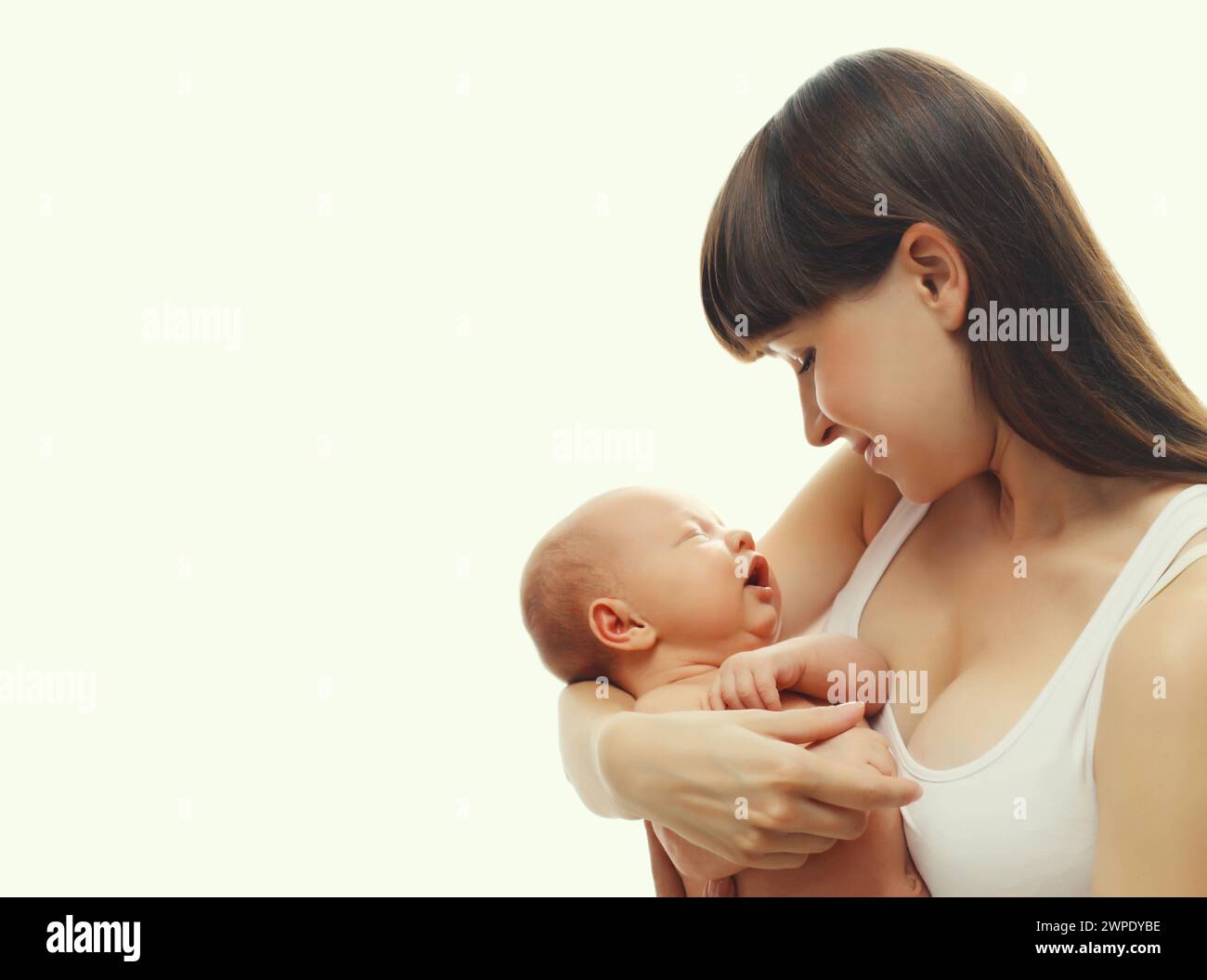 Happy young mother holding cute infant, baby sleeping in arms on white studio background Stock ...
