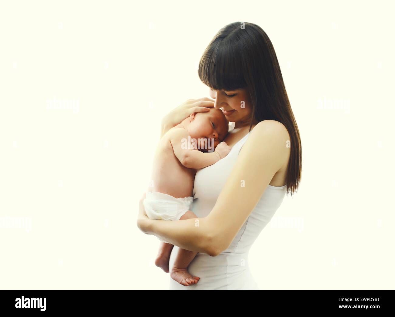 Happy young mother holding cute infant, baby sleeping in arms on white studio background Stock ...